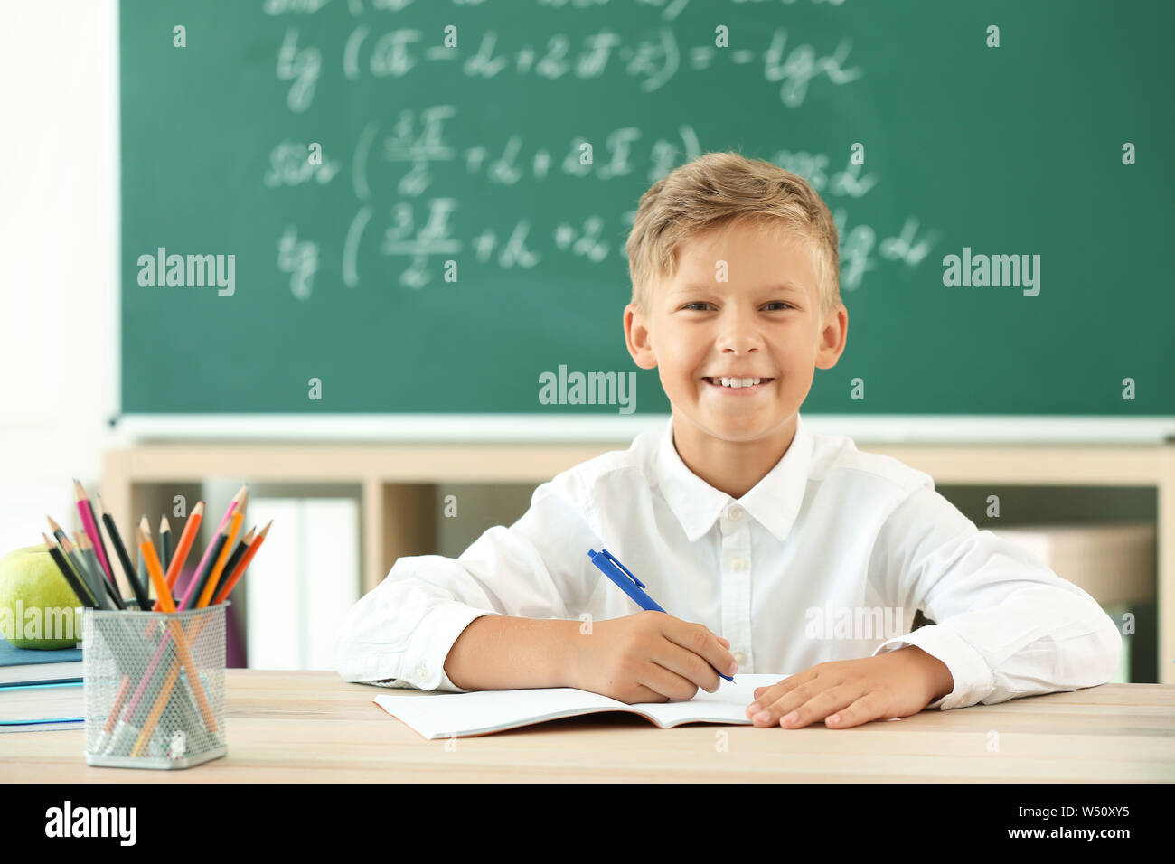 Little boy doing homework in classroom Stock Photo - Alamy