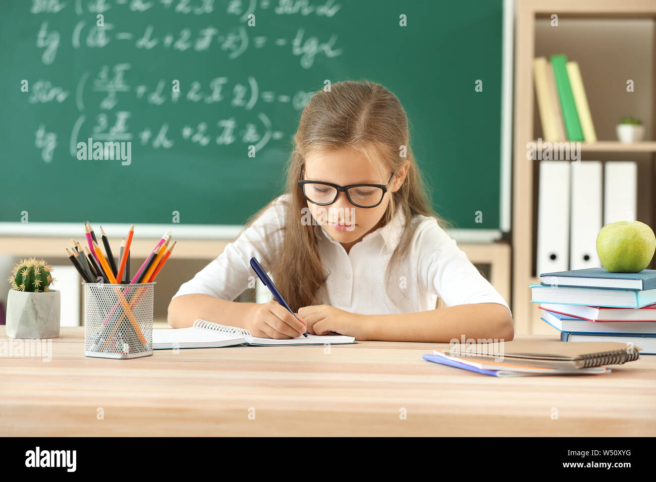 Little girl doing lessons in classroom Stock Photo - Alamy
