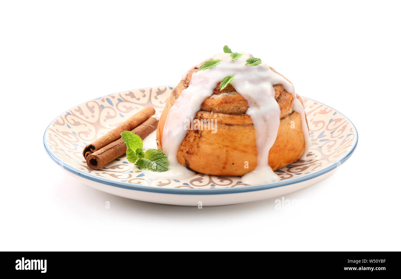 Plate with tasty cinnamon roll on white background Stock Photo - Alamy