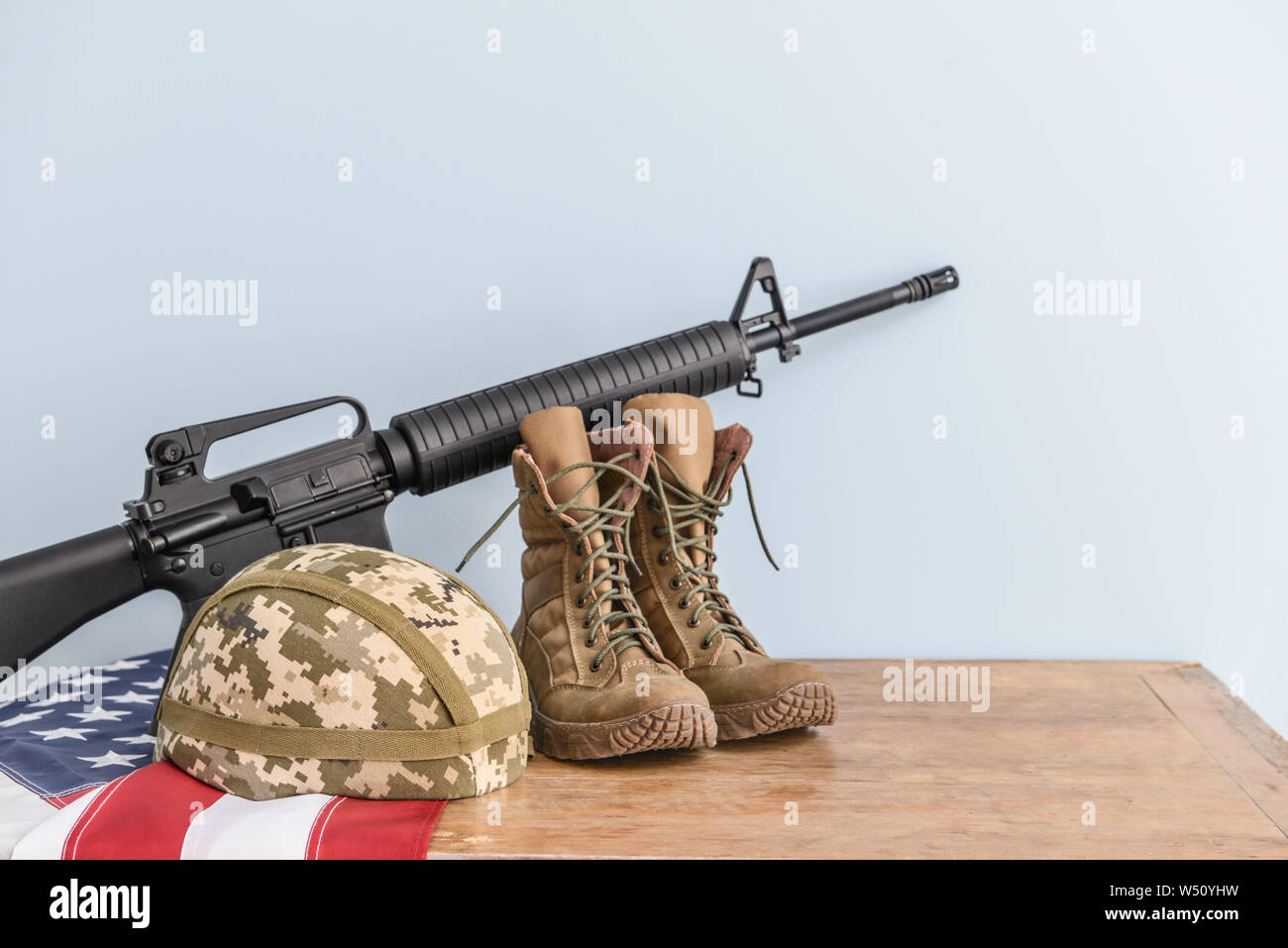 Military helmet, boots, assault rifle and USA flag on table Stock Photo ...