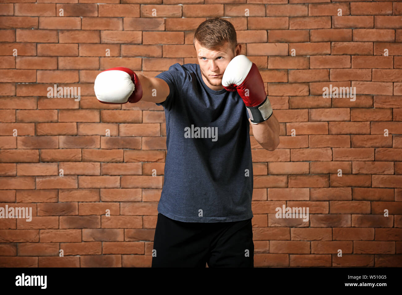 Strong male boxer against brick wall Stock Photo - Alamy