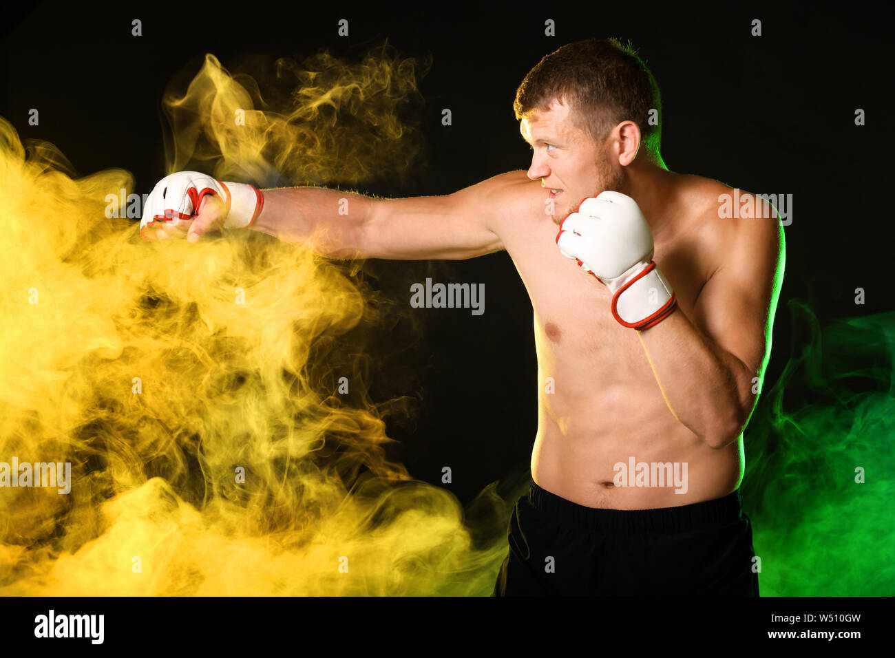 Strong male boxer in smoke on dark background Stock Photo - Alamy