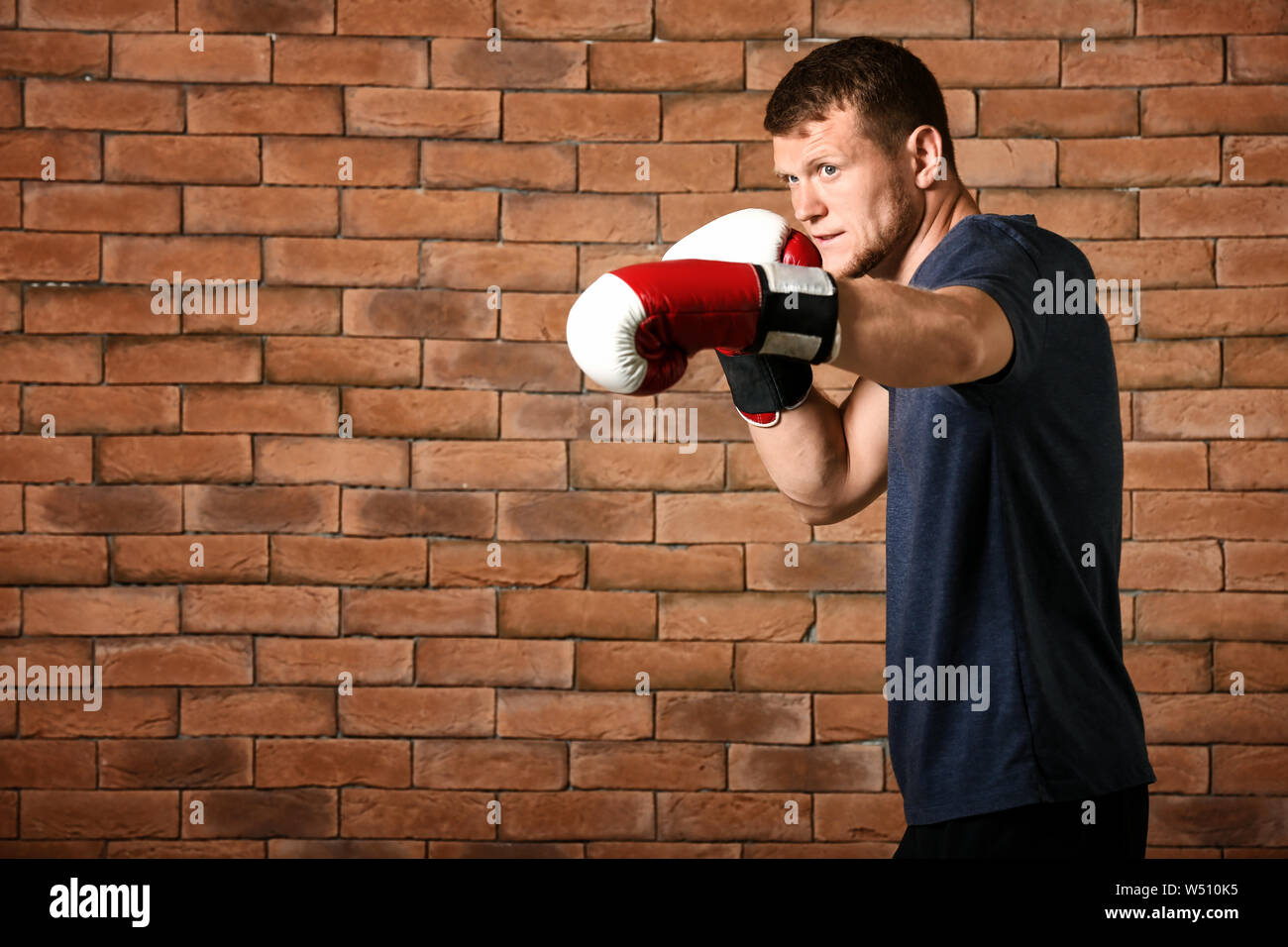 Strong male boxer against brick wall Stock Photo - Alamy