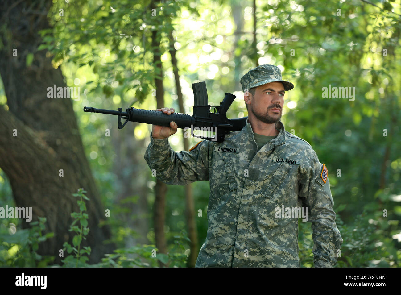 Soldier with assault rifle in forest Stock Photo - Alamy