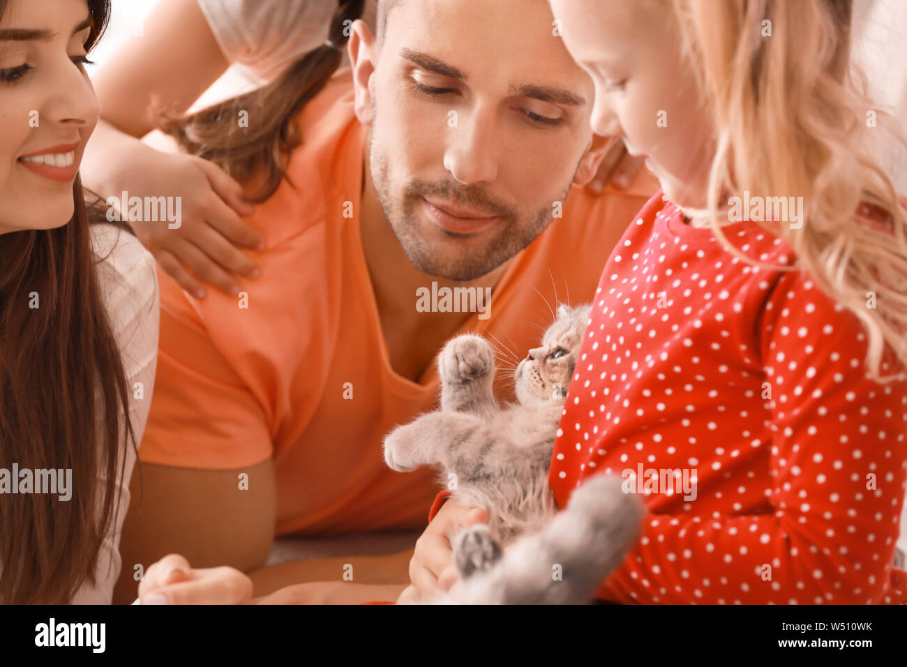 Happy family with cute cat at home Stock Photo - Alamy