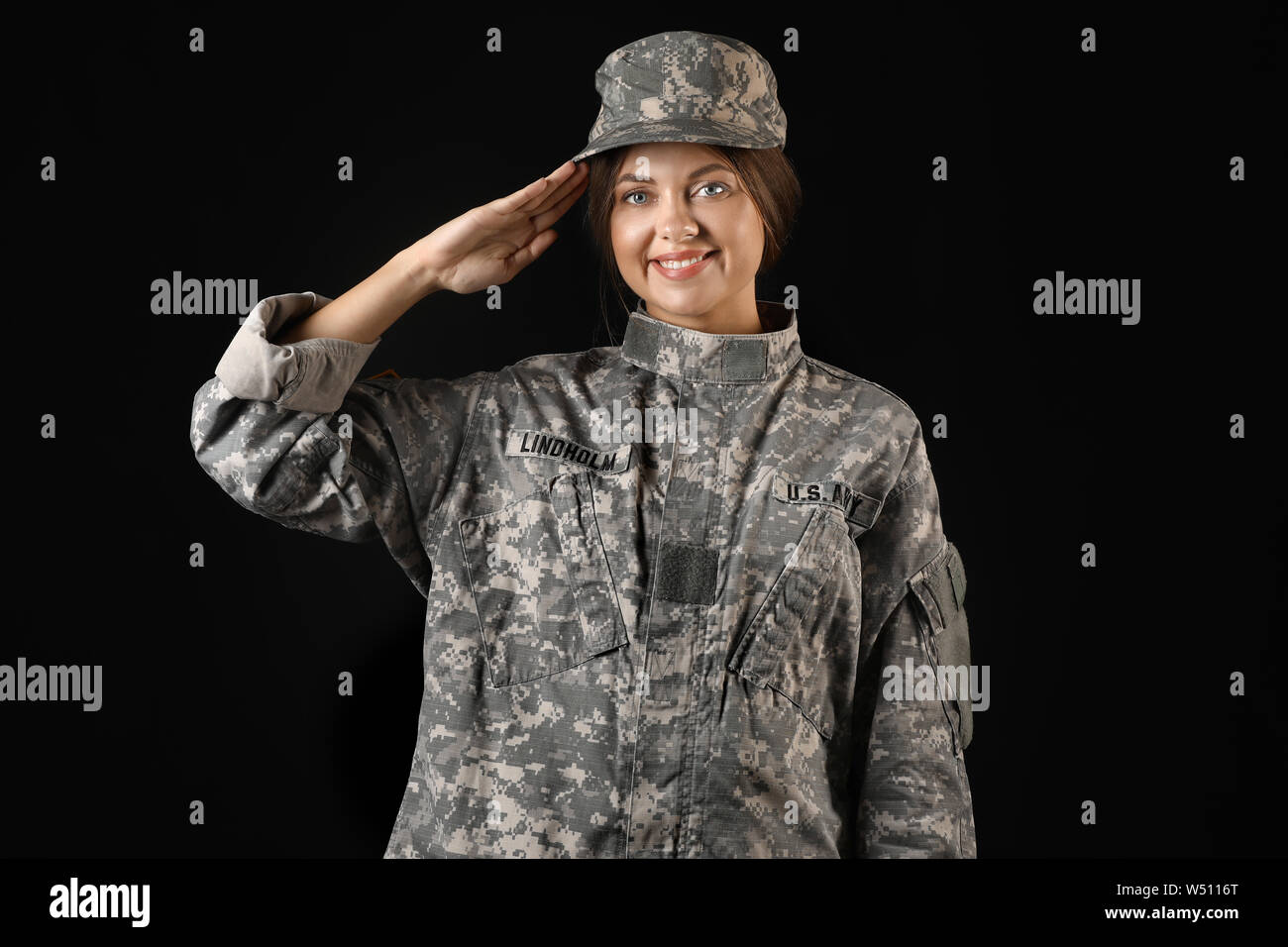 Saluting female soldier on dark background Stock Photo - Alamy