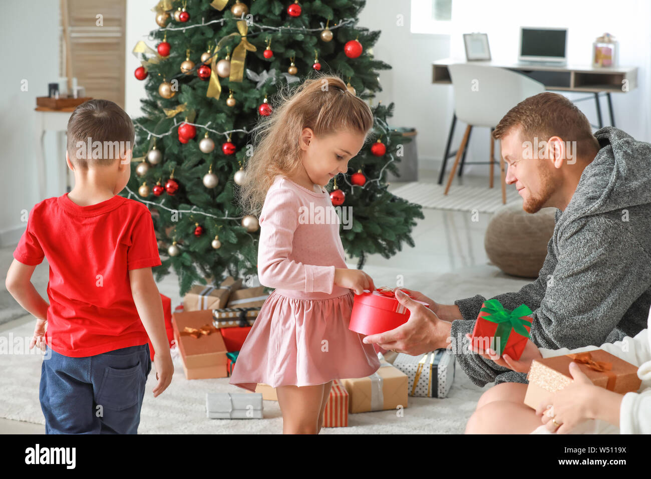 Happy children greeting their parents on Christmas eve Stock Photo - Alamy