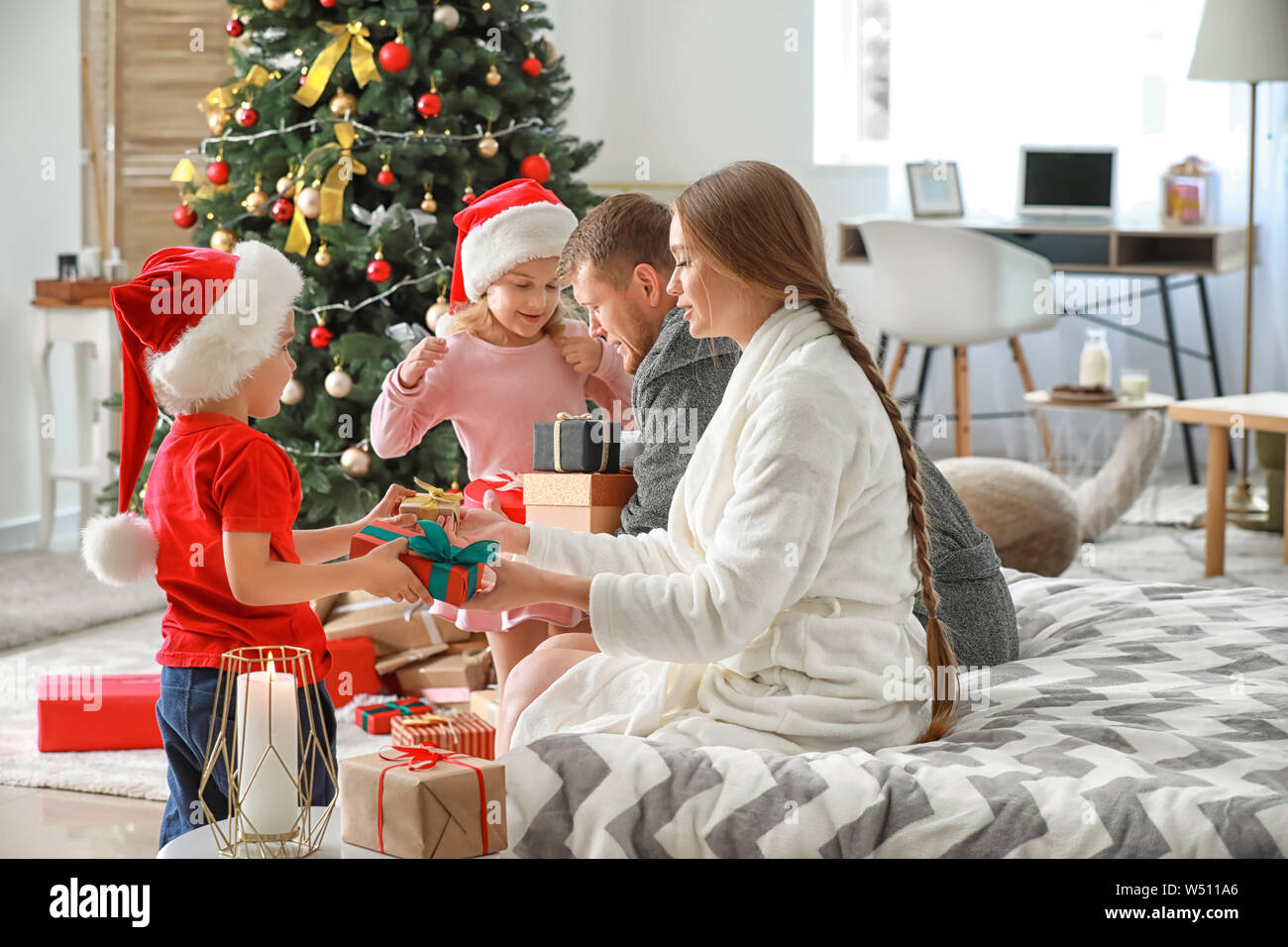 Happy children greeting their parents on Christmas eve Stock Photo - Alamy