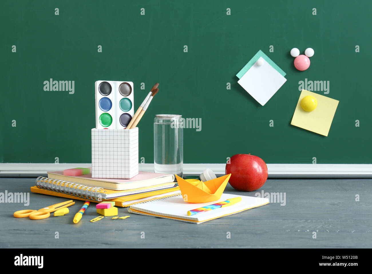 Set of school supplies on table in classroom Stock Photo - Alamy
