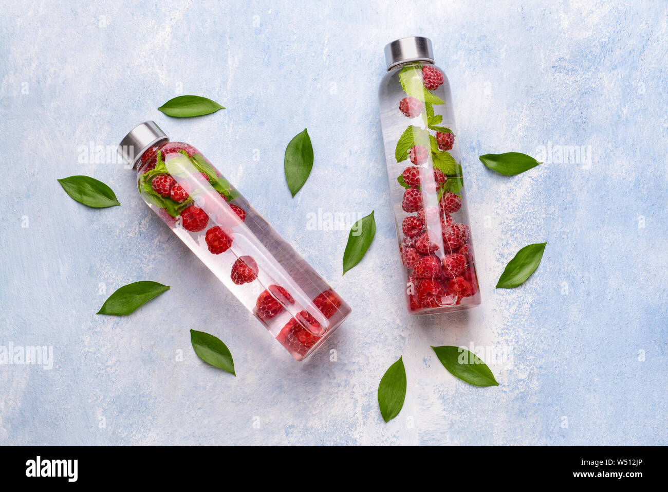 Bottles of infused water on light color background Stock Photo - Alamy