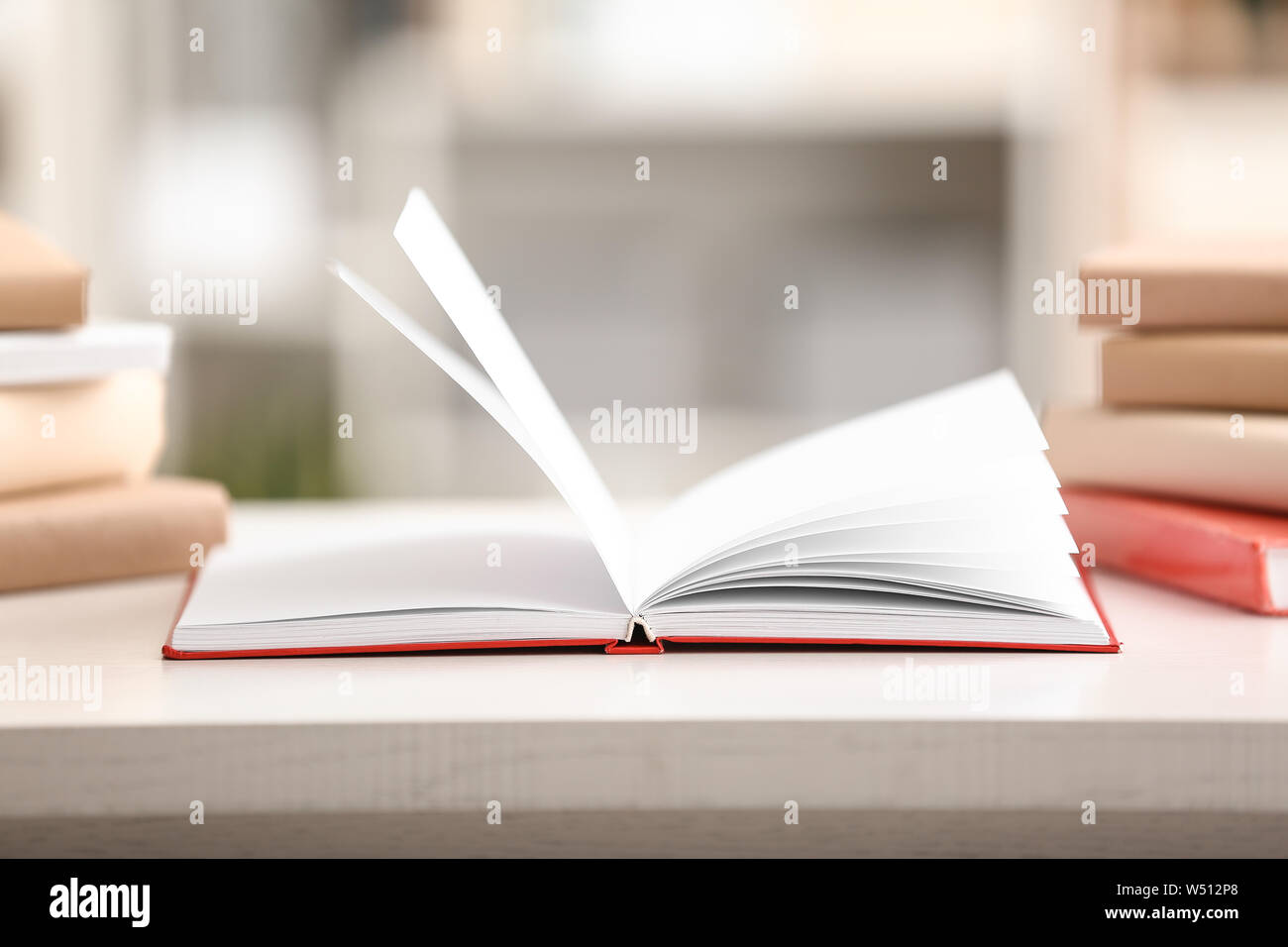 Open book on table in library Stock Photo - Alamy