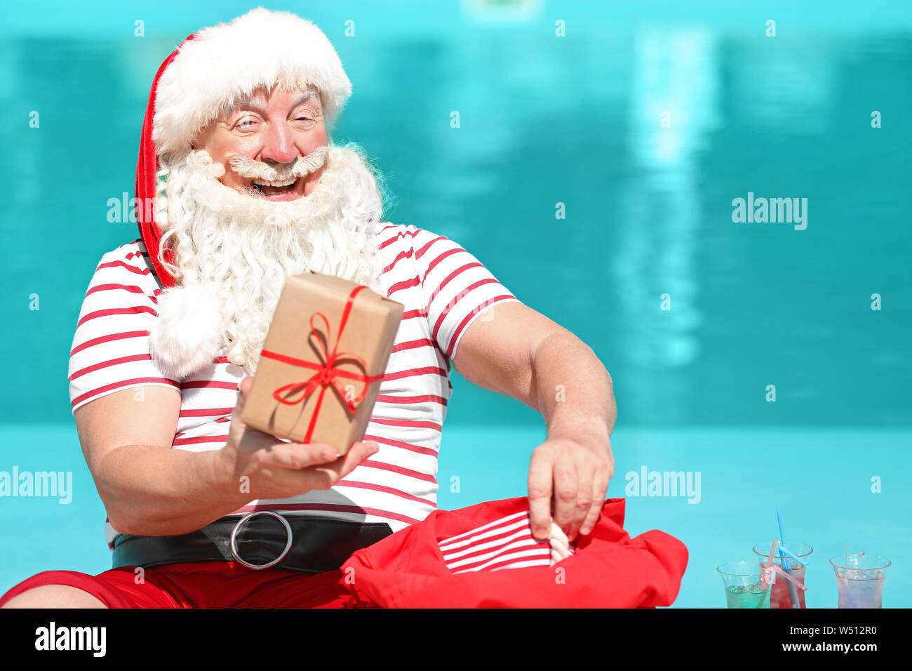 Santa Claus with gifts near swimming pool at resort Stock Photo - Alamy