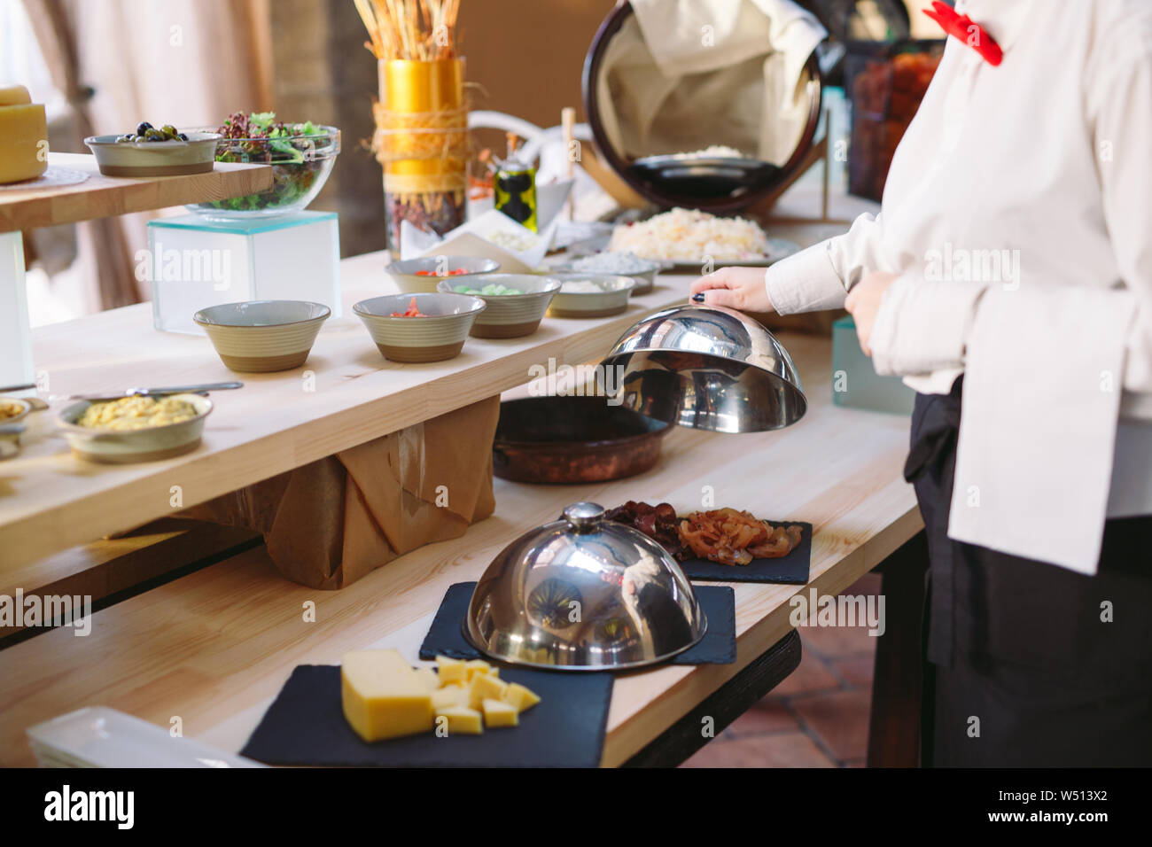 Buffet. The waiter sets the table. Fruits, salads Stock Photo - Alamy