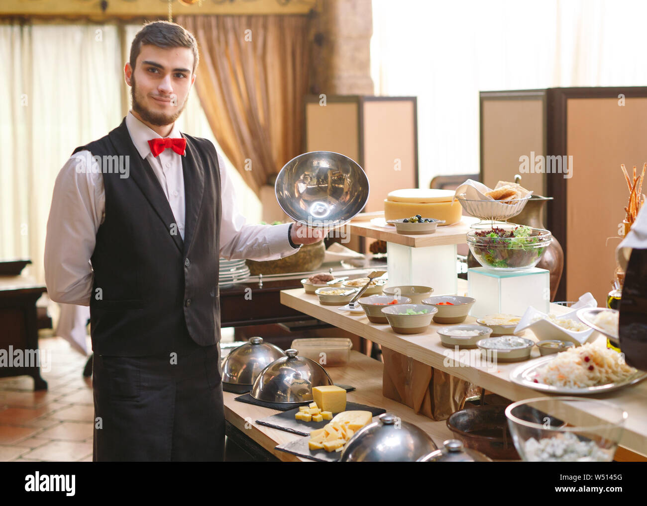 Buffet. The waiter sets the table. Fruits, salads Stock Photo - Alamy