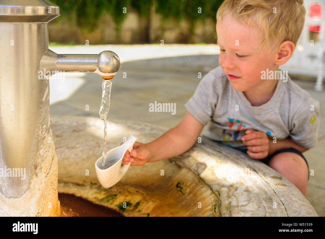 Little boy catching a water from hot mineral spring in Karlovy Vary in ...
