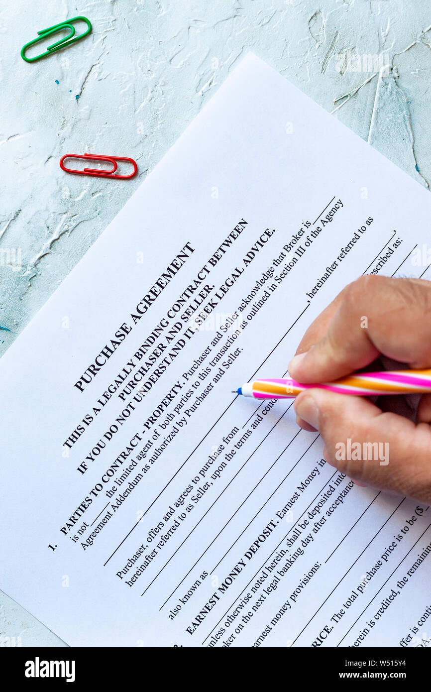 Person Filling blank Purchase agreement form. View from above Stock ...