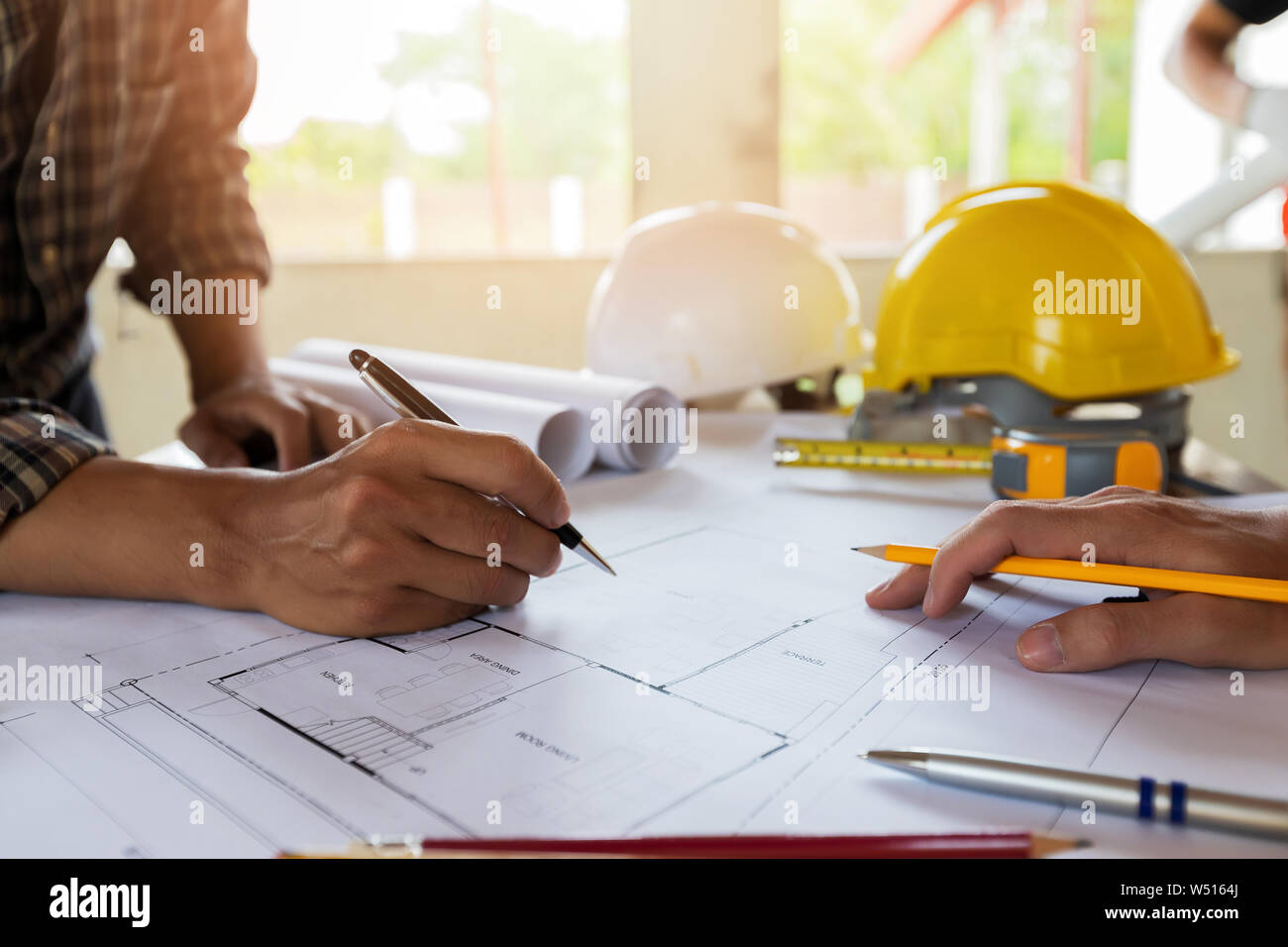 An architect or engineer writing on blueprint, architectural concept ...