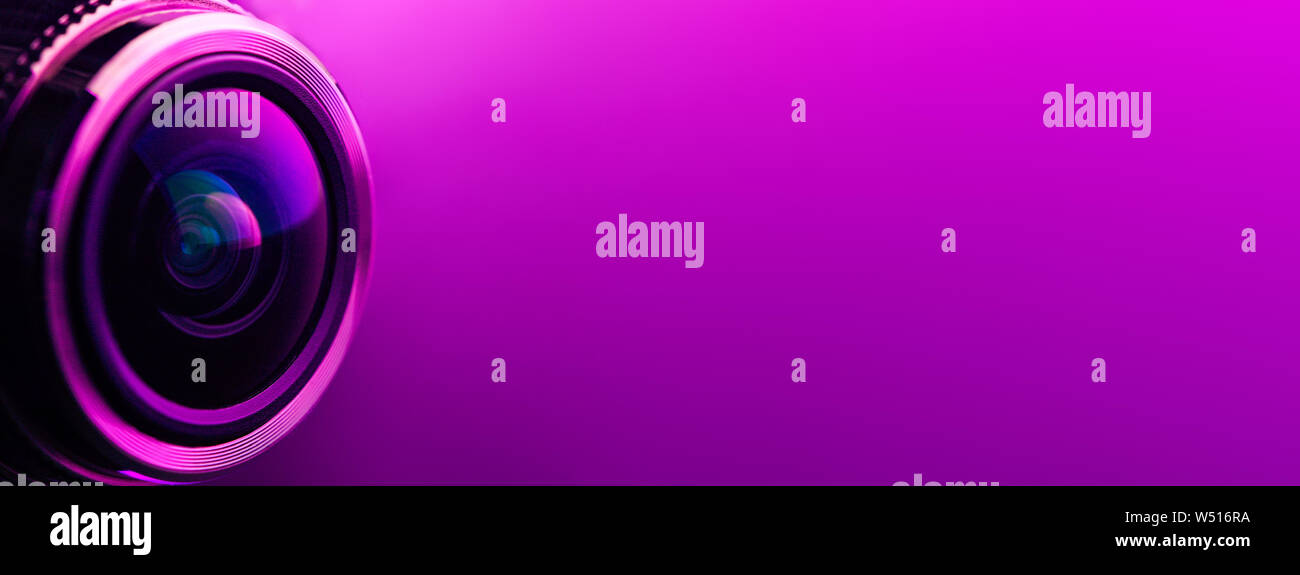 Banner. Camera lens and dark purple backlight. Side view of the lens of ...