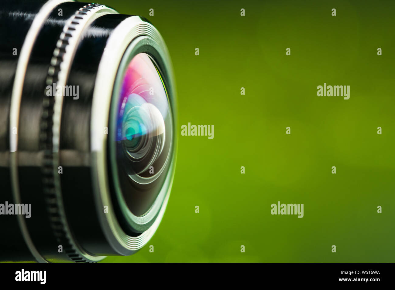 Camera lens and green backlight. Side view of the lens of camera on ...