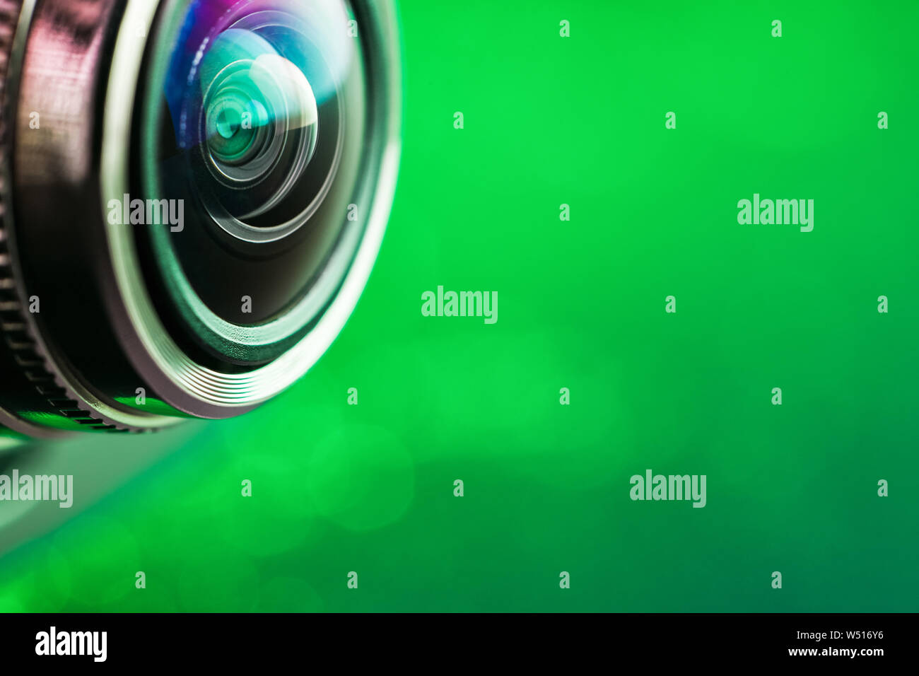 Camera lens and green backlight. Side view of the lens of camera on ...