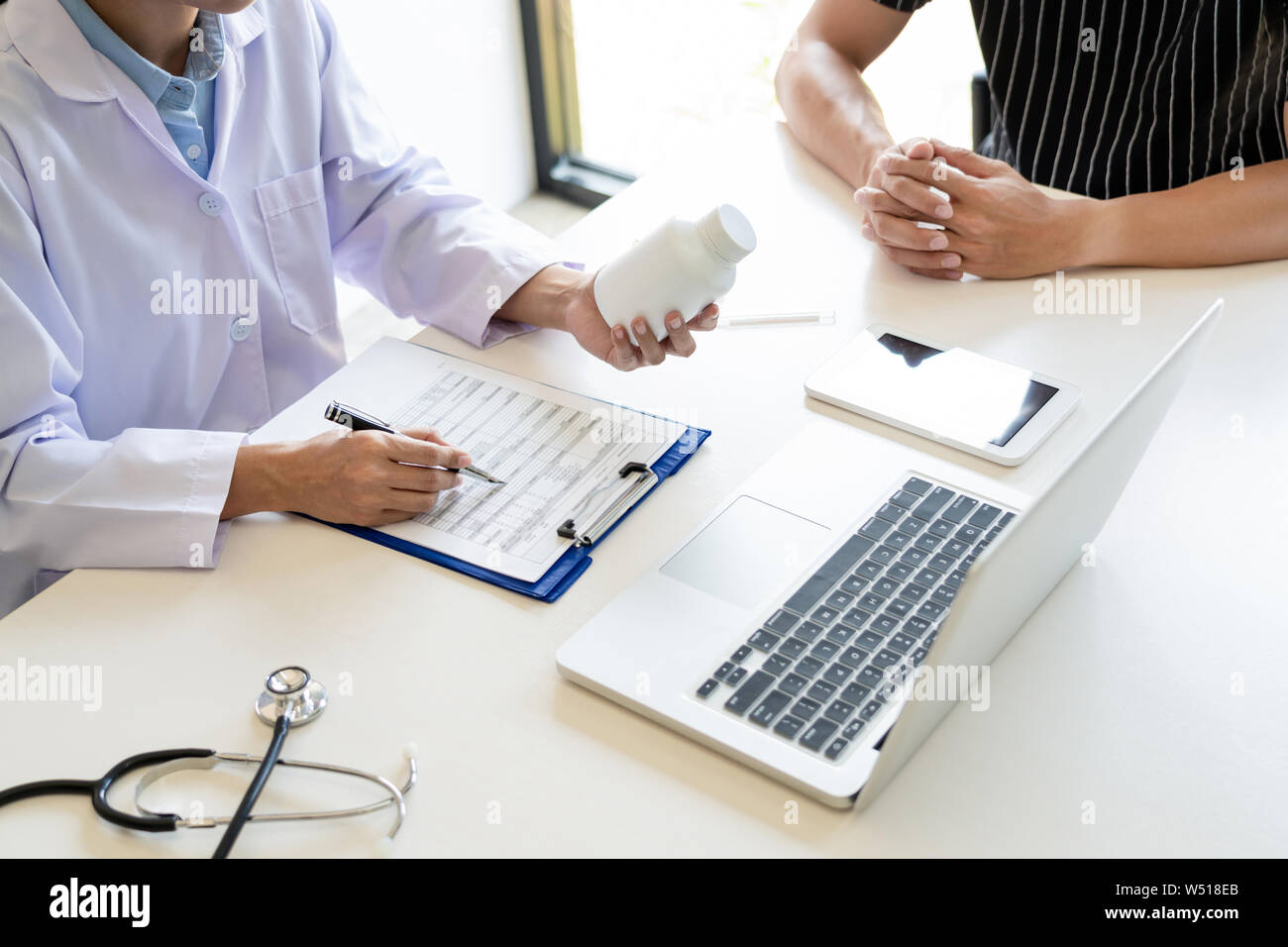 health care concept, doctor give a medicine bottle of drugs pills and ...