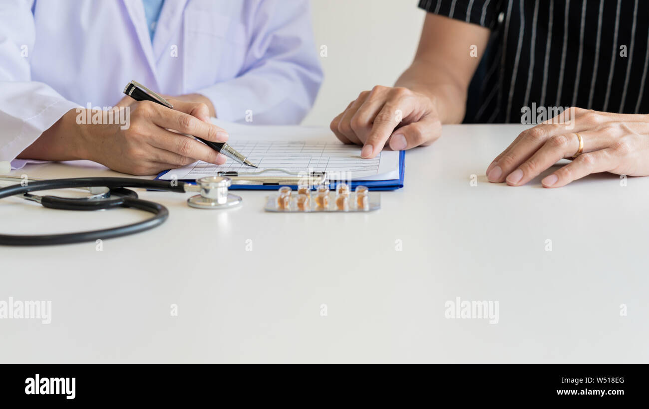 Doctor explaining for patient and showing medical records informations ...