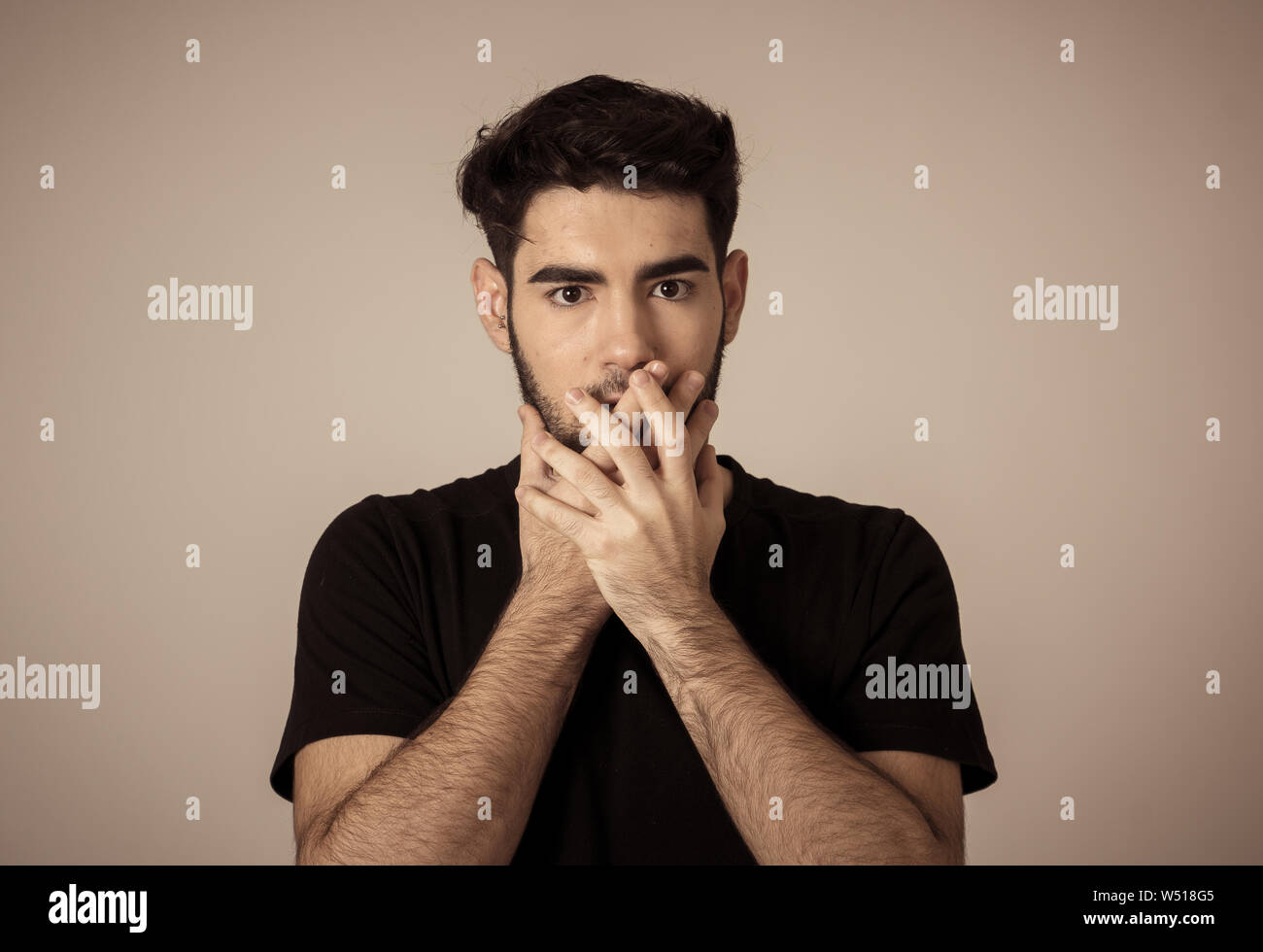 Young man feeling scared and shocked making fear anxiety gestures ...