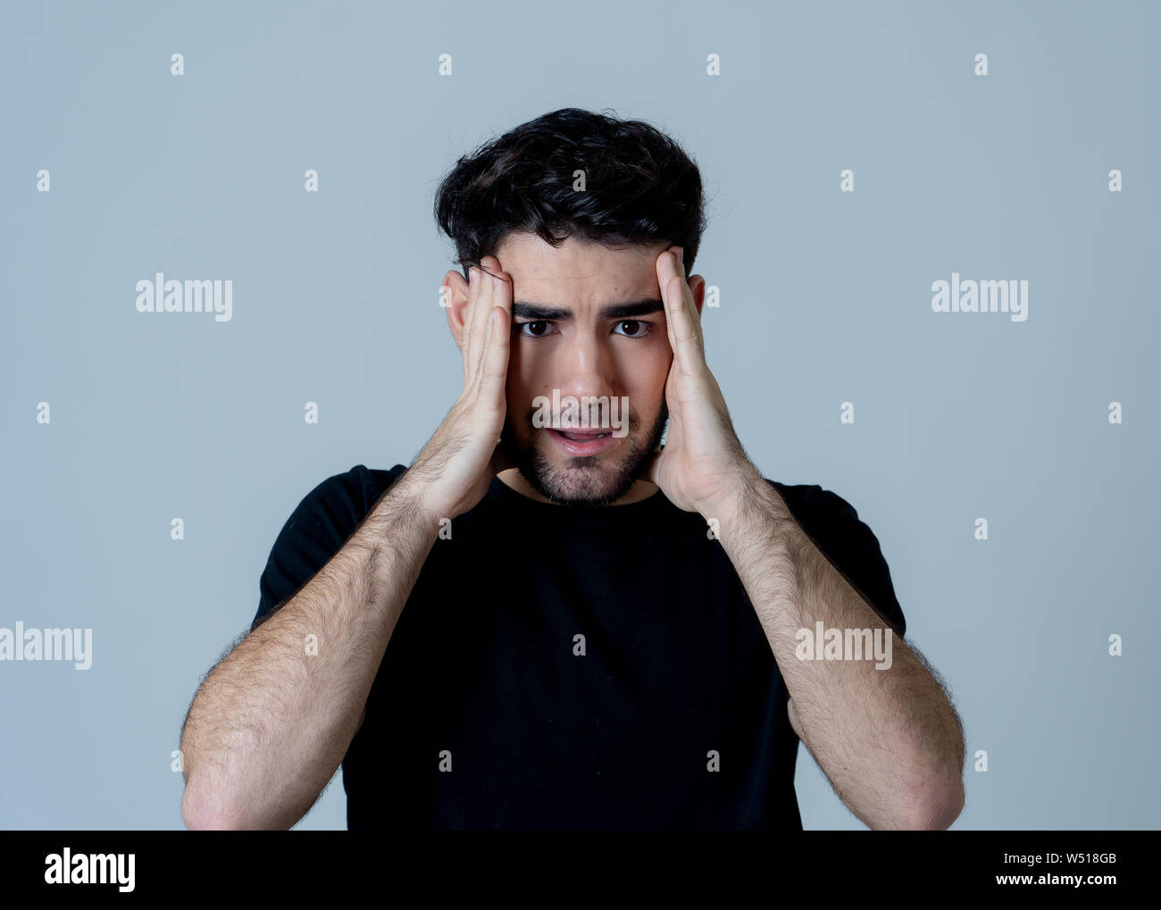 Young man feeling scared and shocked making fear anxiety gestures ...