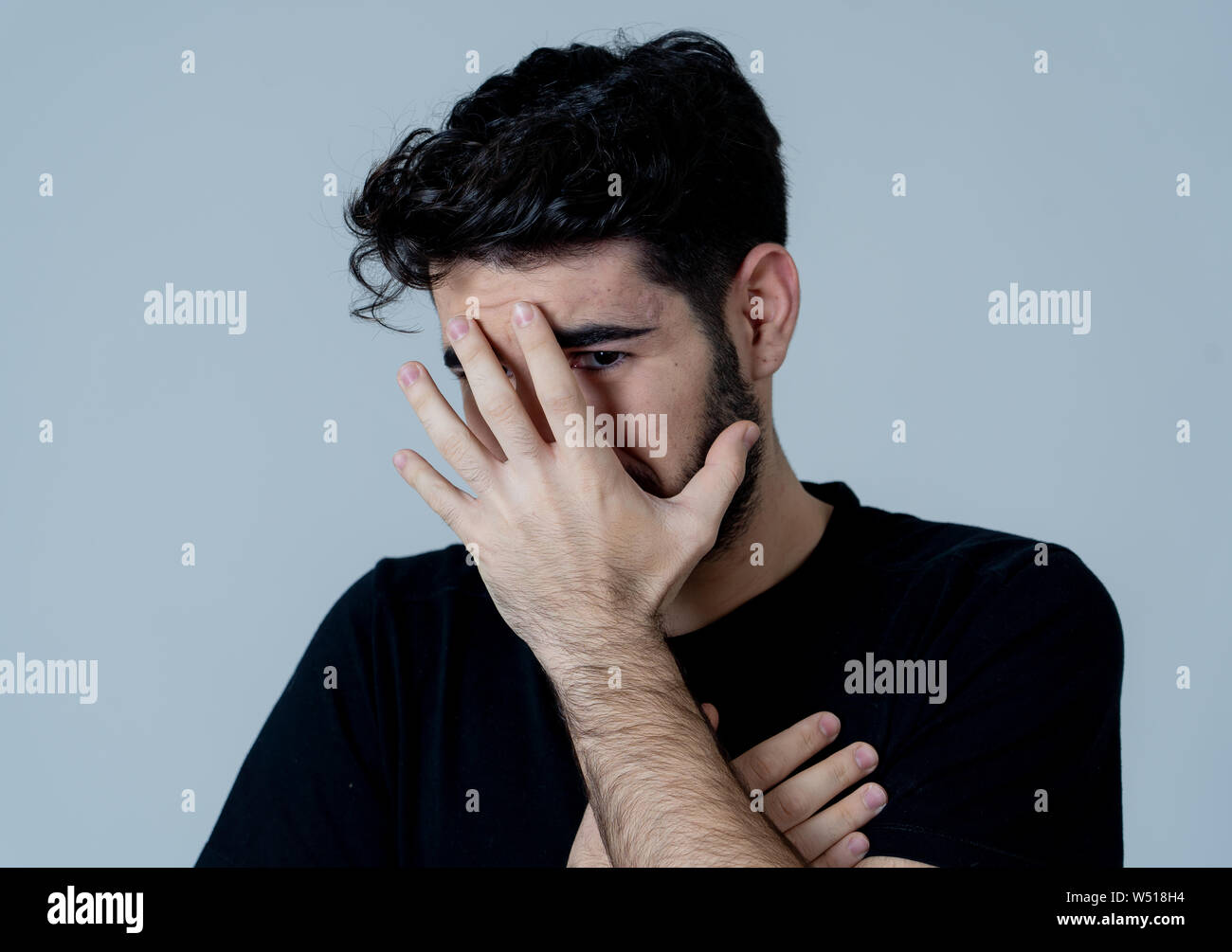 Young man feeling scared and shocked making fear anxiety gestures ...