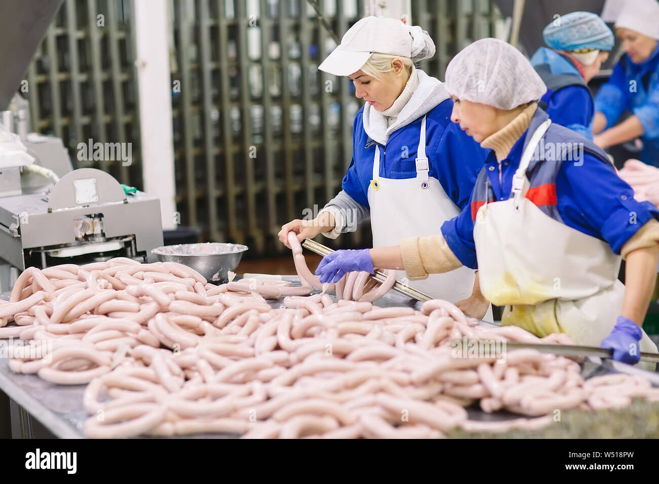Butchers processing sausages at a meat factory Stock Photo - Alamy