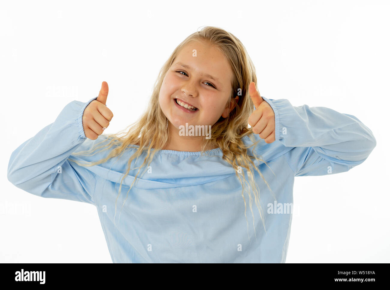 Portrait of young schoolgirl feeling happy smiling and making thumbs up ...