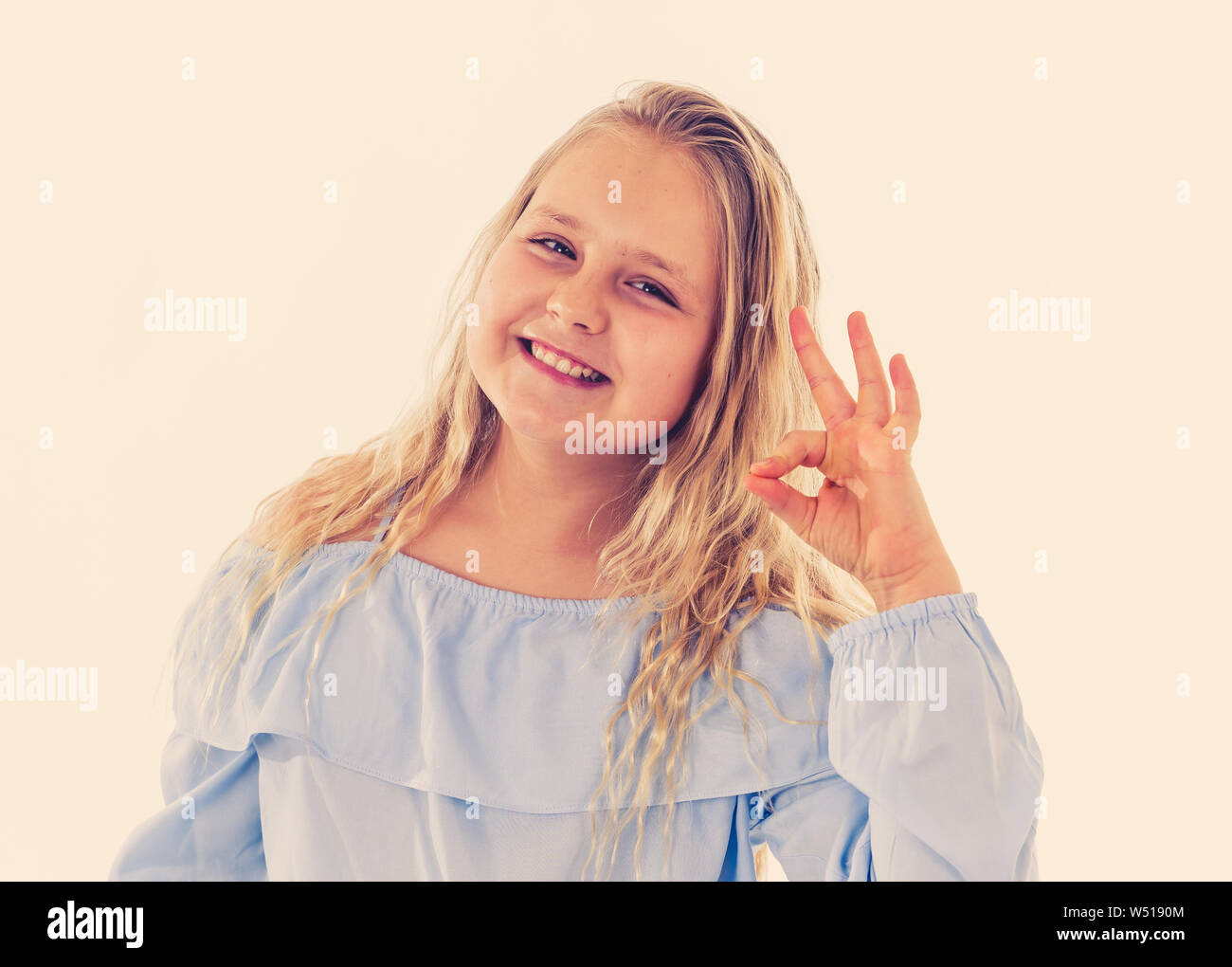 Portrait of young schoolgirl feeling happy smiling and making ok good ...