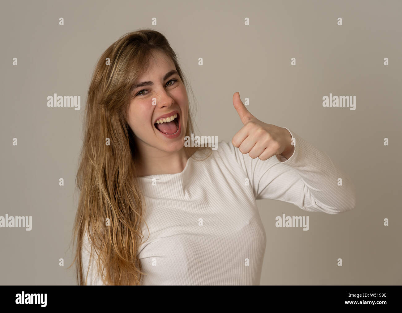 Studio portrait of young beautiful teenager girl woman looking happy ...