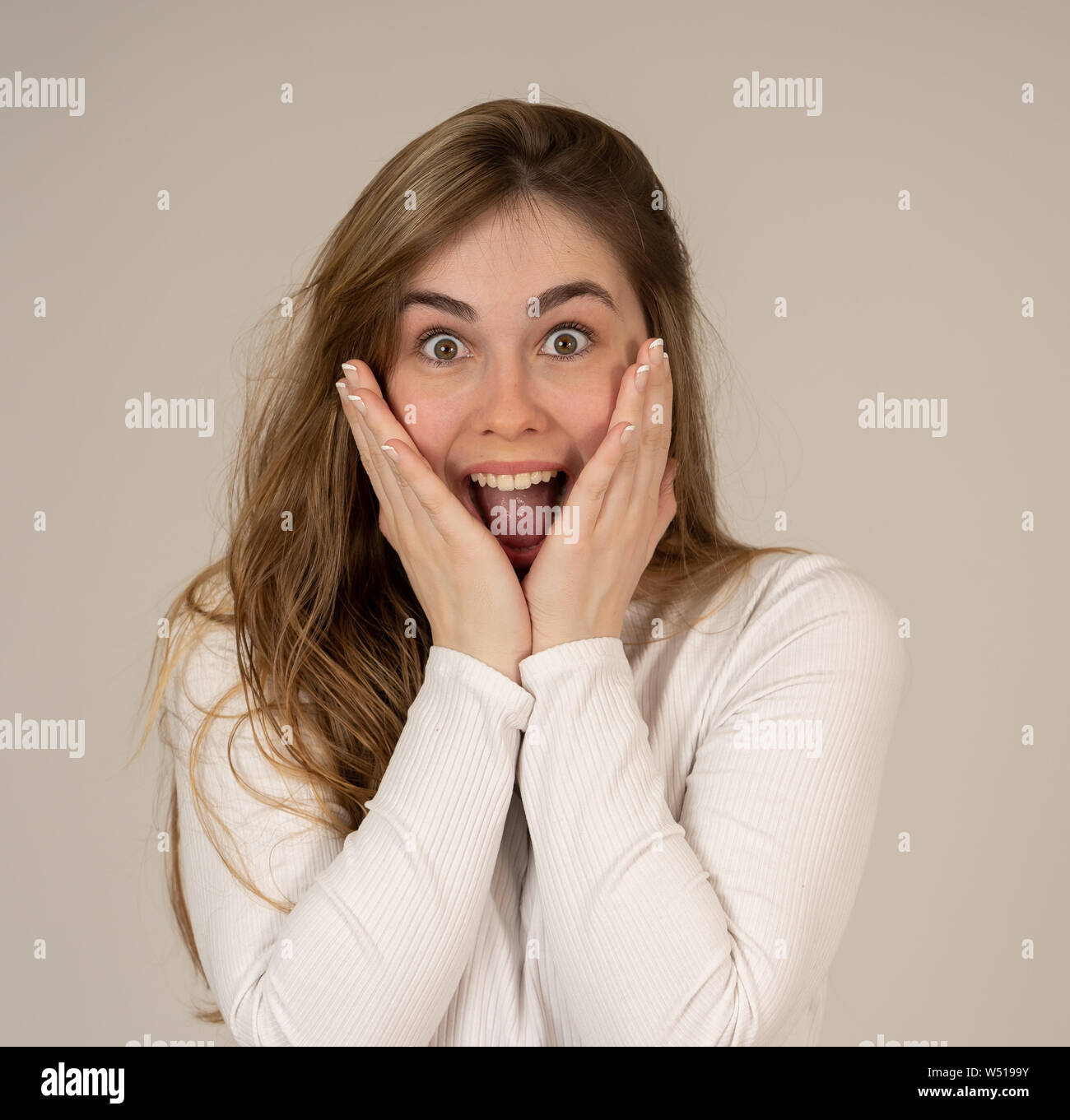 Beautiful young blonde teenager woman with happy face making surprised ...