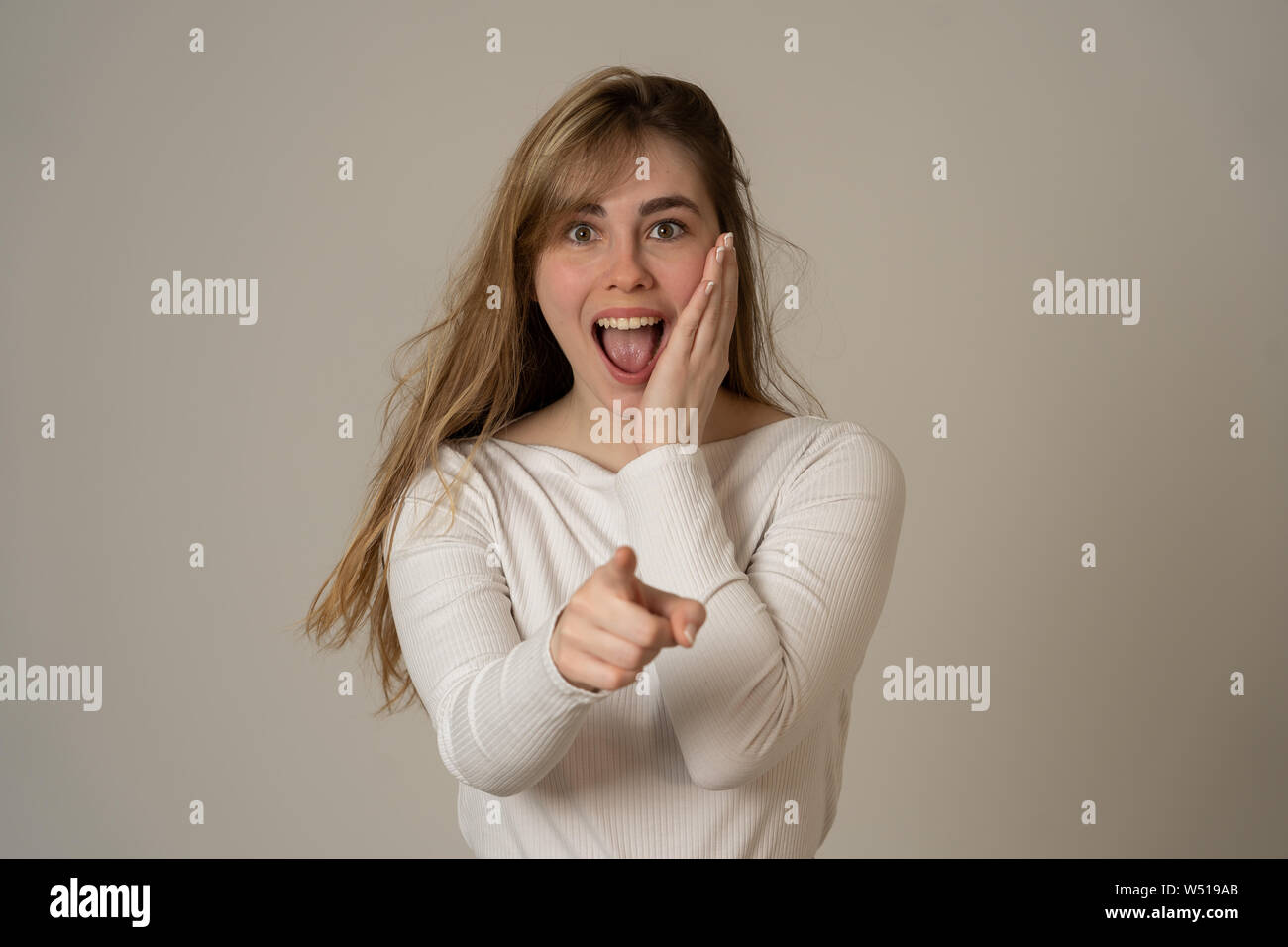 Beautiful young blonde teenager woman with happy face making surprised ...