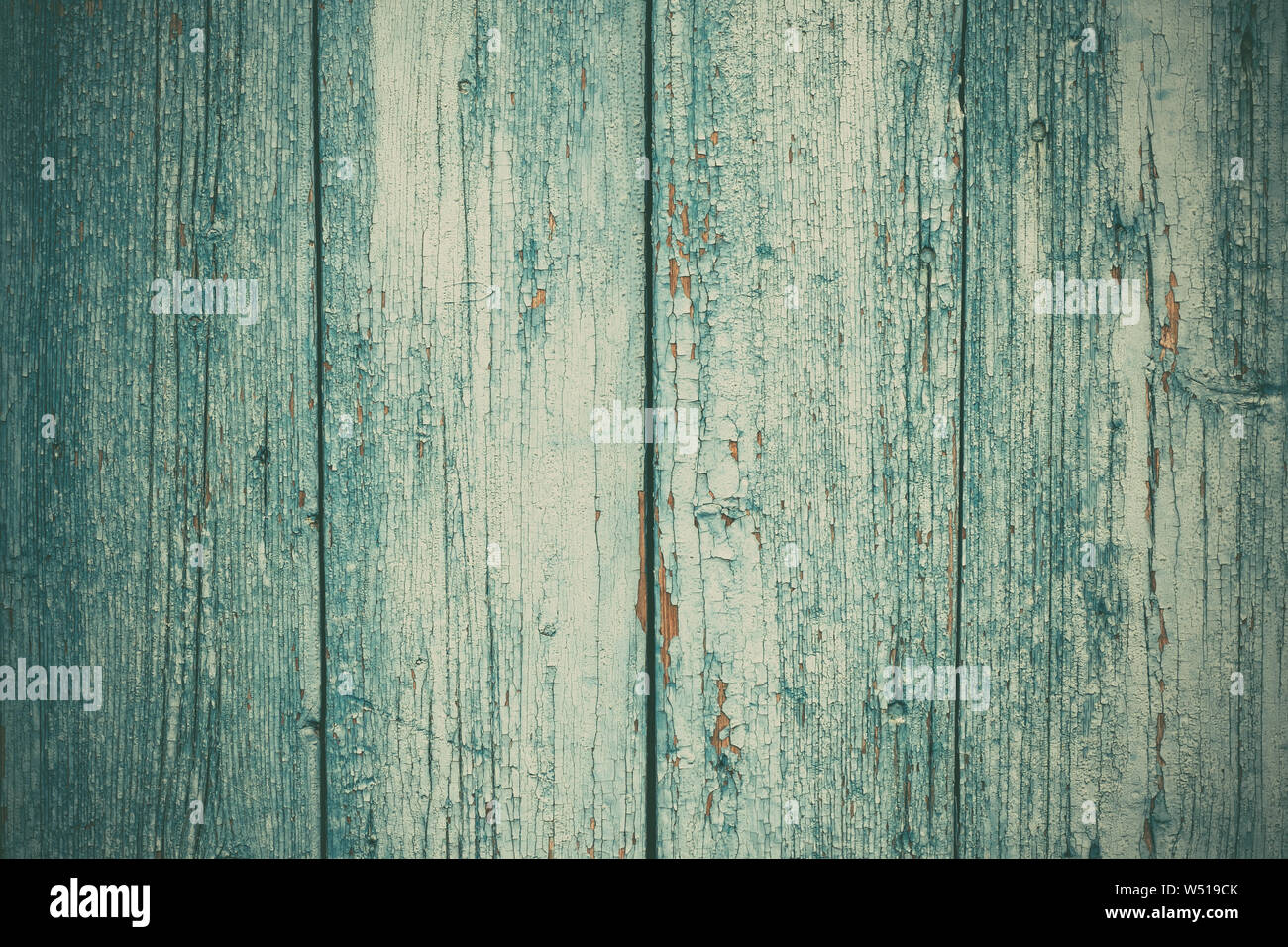 Dark dilapidated cracked boards, green fence. Painted wood old table ...