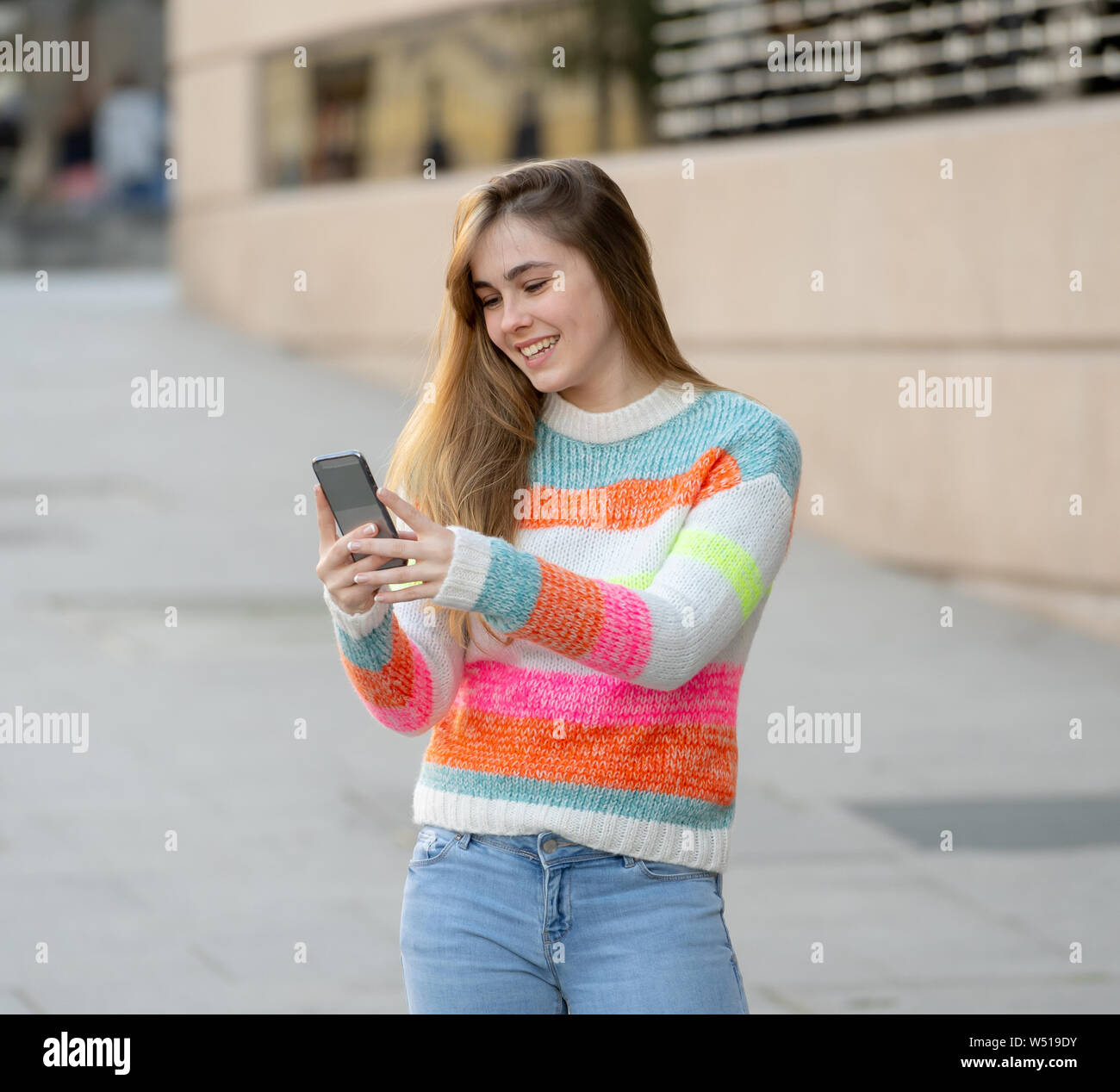 Pretty happy student woman chatting online on smart phone using social ...