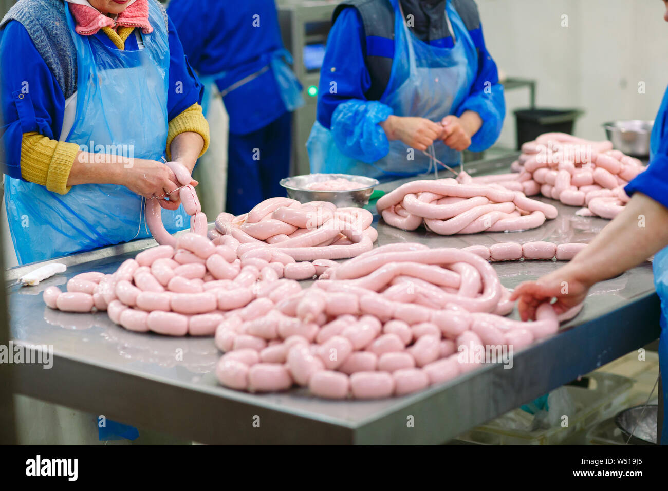 Butchers processing sausages at a meat factory Stock Photo - Alamy