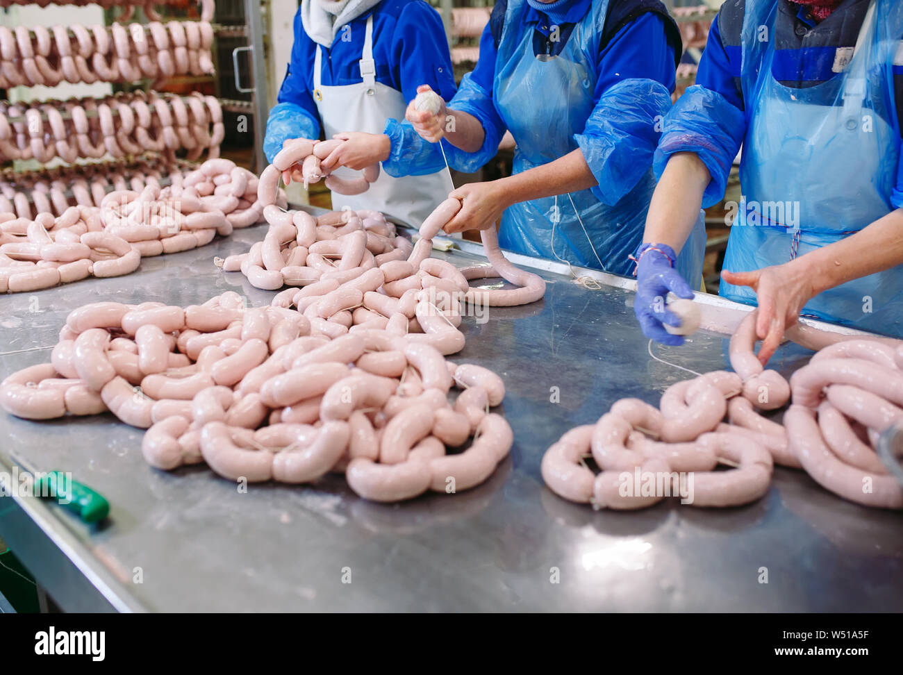 Butchers processing sausages at a meat factory Stock Photo - Alamy