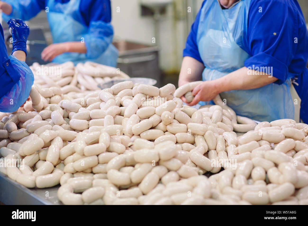 Butchers processing sausages at a meat factory Stock Photo - Alamy