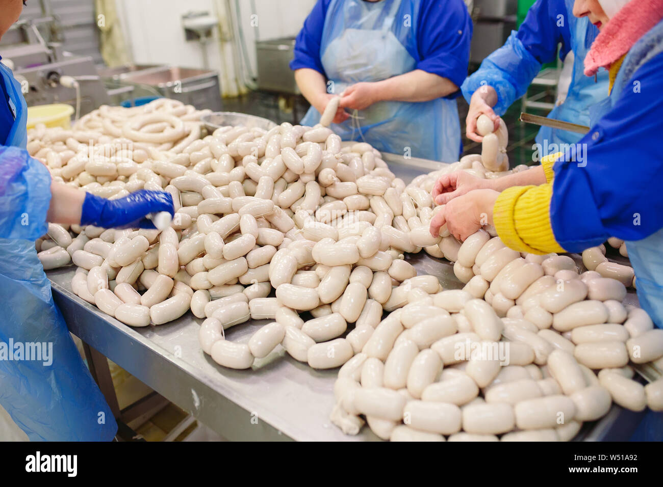 Butchers processing sausages at a meat factory Stock Photo - Alamy