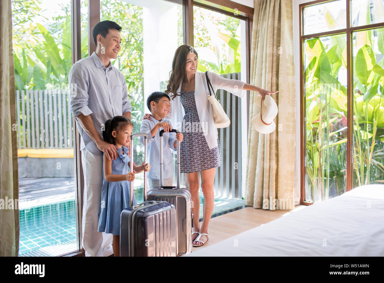 Happy young family in hotel room Stock Photo - Alamy