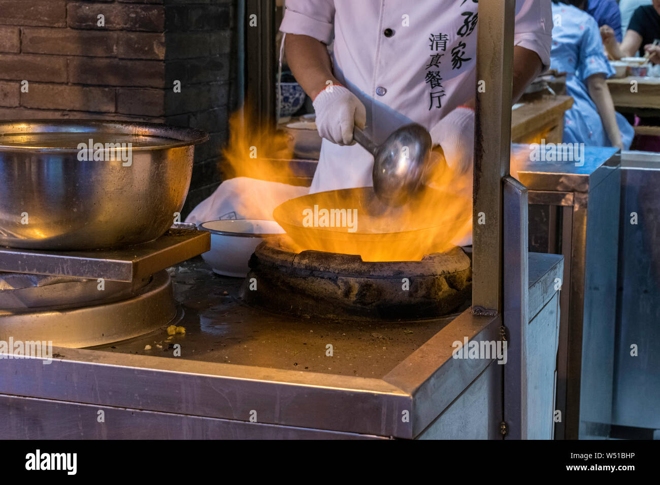 Wok cooking, flash in the pan, fire flames Stock Photo - Alamy