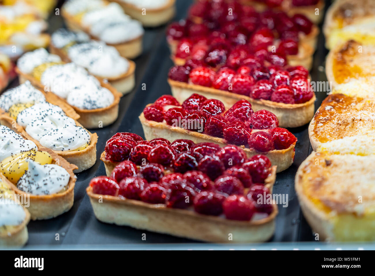 Colorful raspberry cream cheese tart and fruit tart in bakery Stock ...