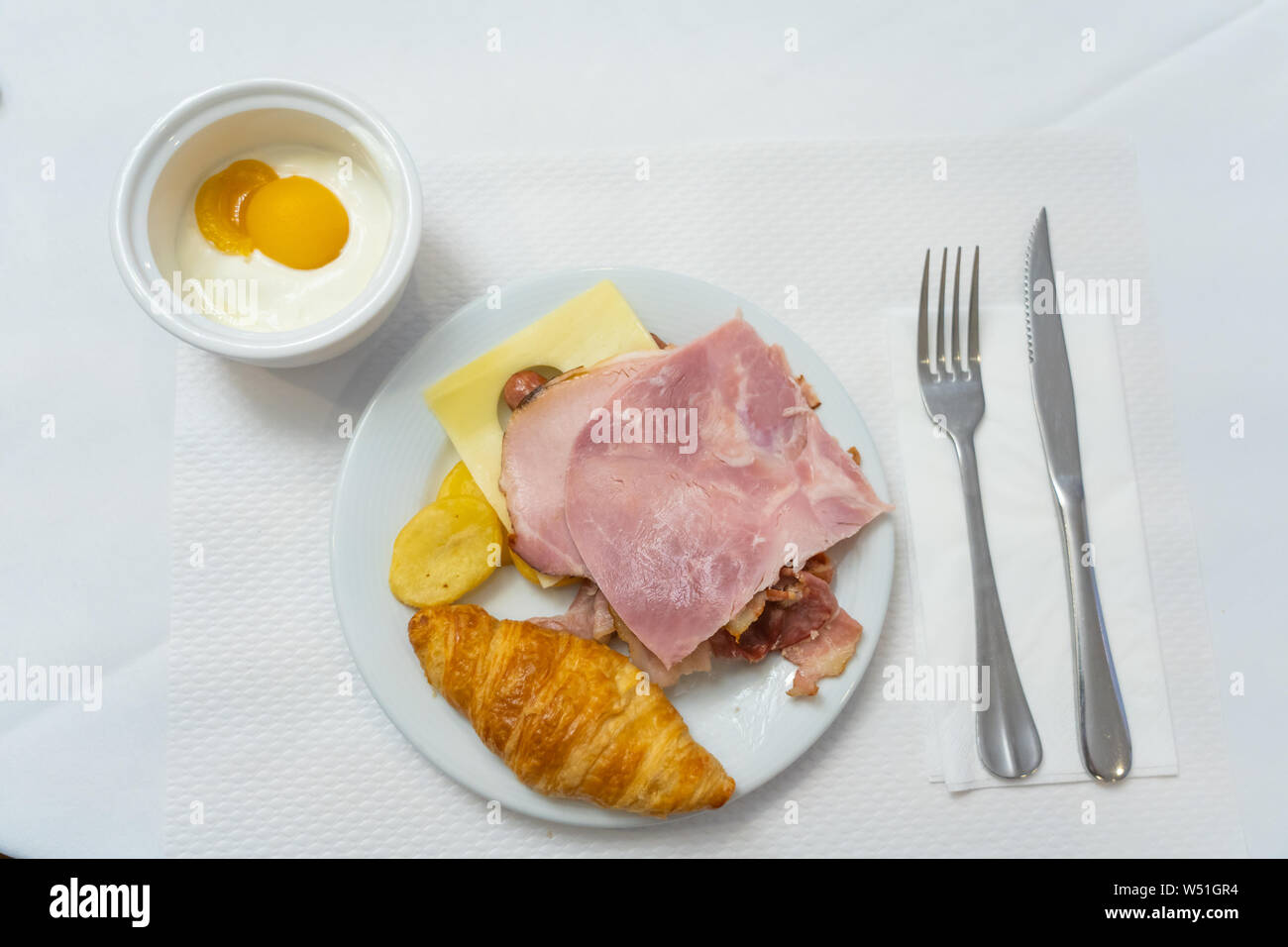 Typical European breakfast with cheese ham croissant and fruit yogurt ...