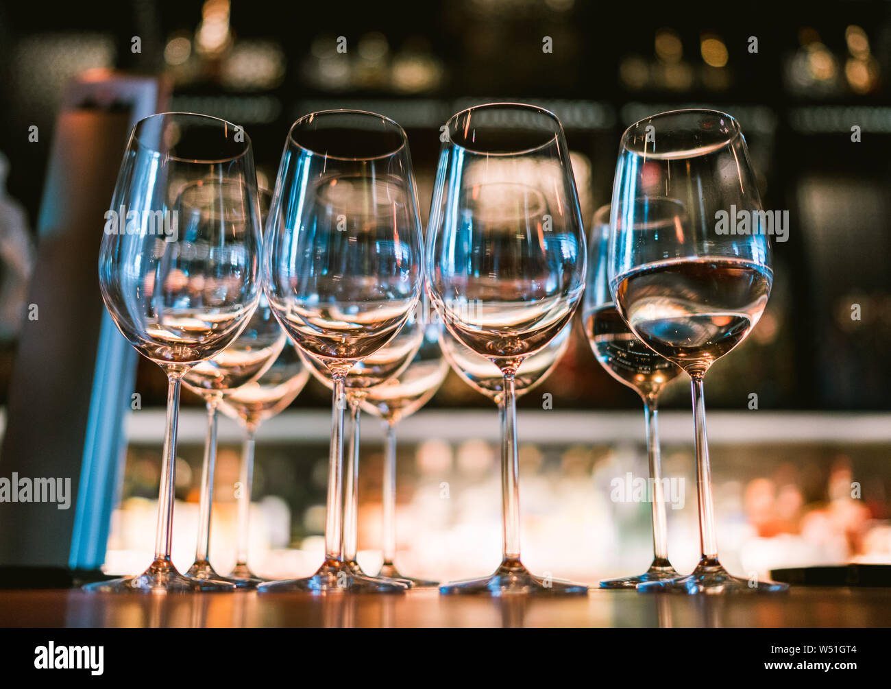 Wine glasses setting on bar with lights from background Stock Photo - Alamy
