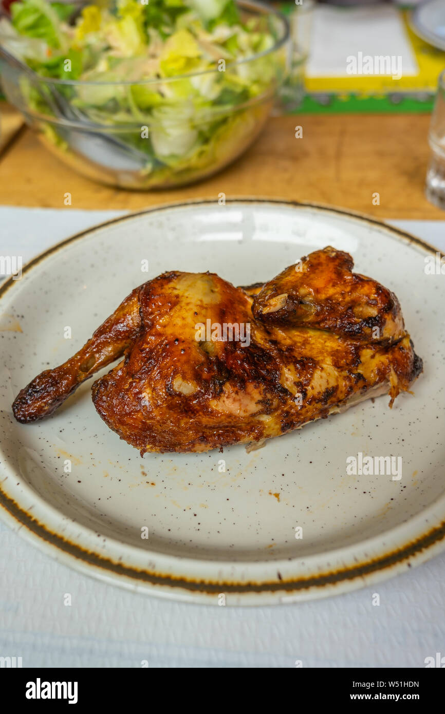 Crispy half roasted chicken on white plate in restaurant Stock Photo ...