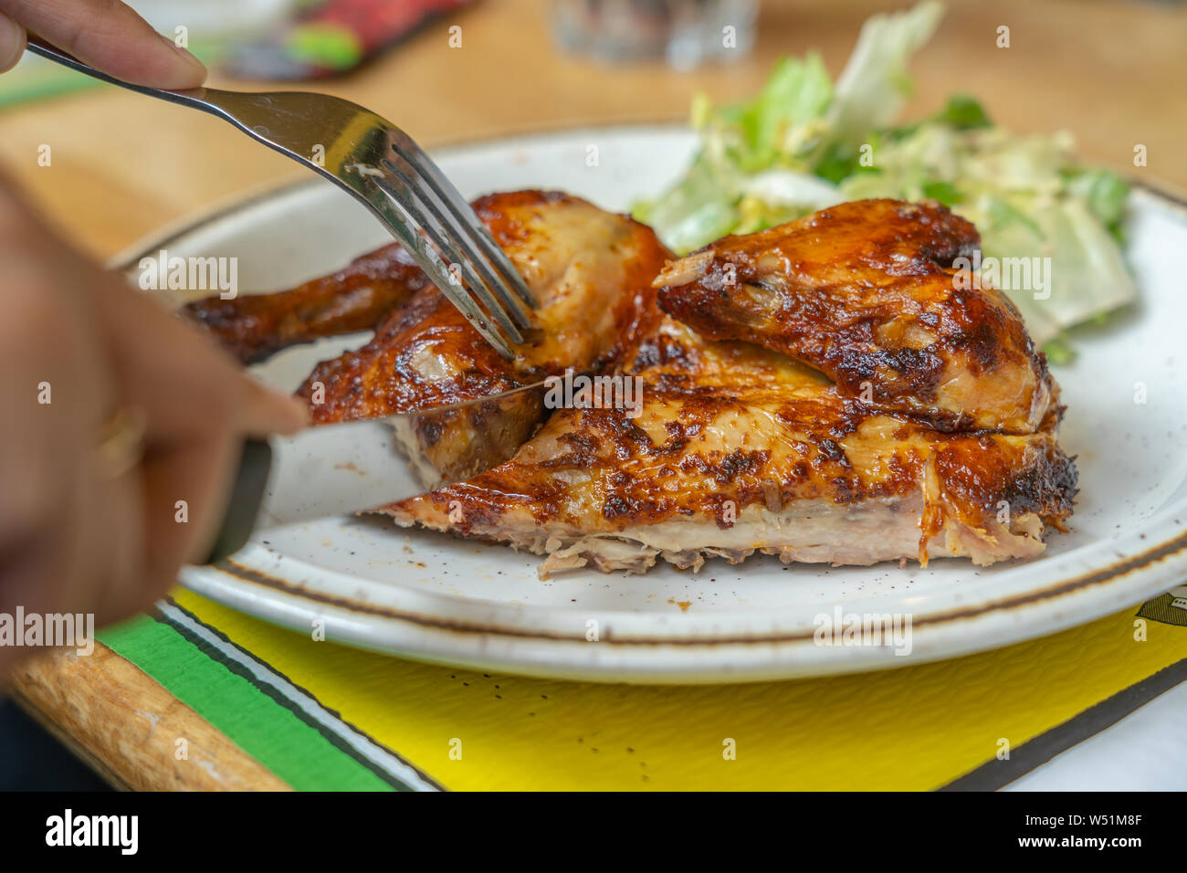 Human hand holding knife and fork and eating grilled chicken Stock ...