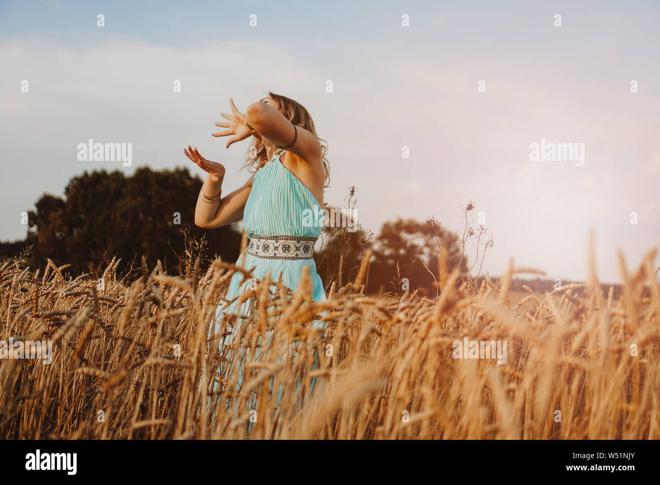 Beautiful Young Woman Dancing In The Field at sunset Stock Photo - Alamy