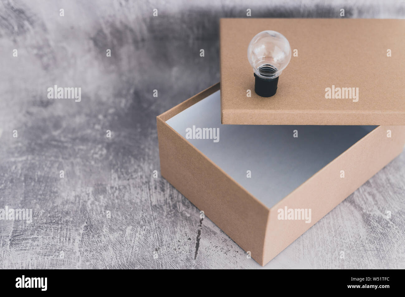 think outside the box concept: open empty box with one lightbulb ...
